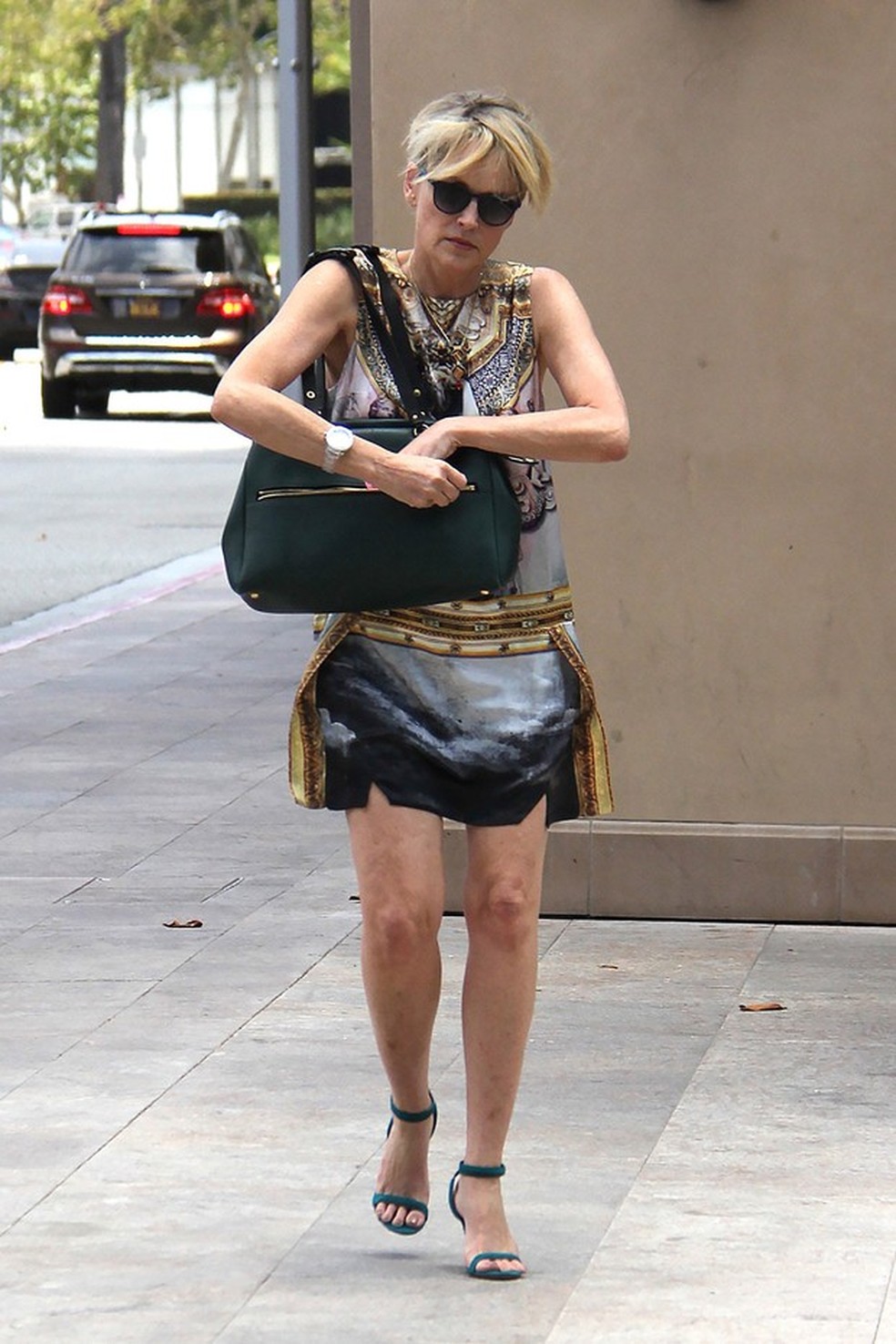 De vestido curtinho e sem mangas, Sharon Stone prova que está em forma