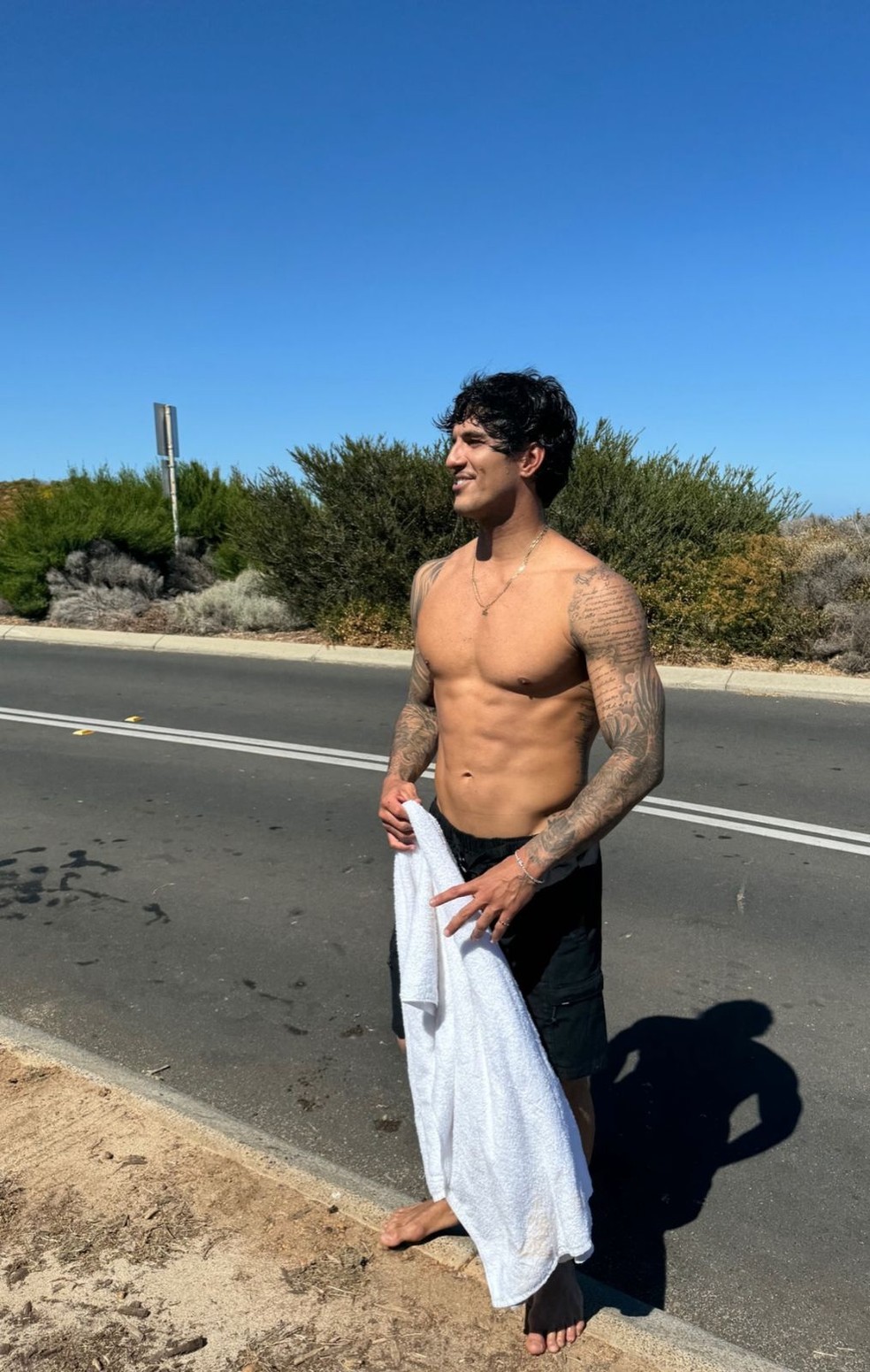 Gabriel Medina posa sem camisa em meio de estrada