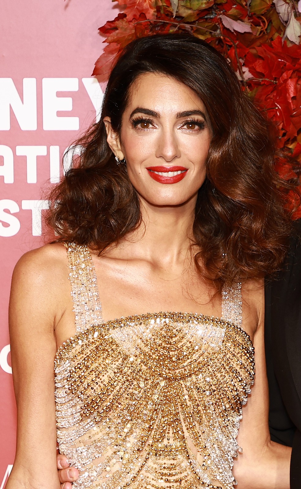 Amal Clooney se inspira nos anos 20 ao vestir Versace dourado em evento