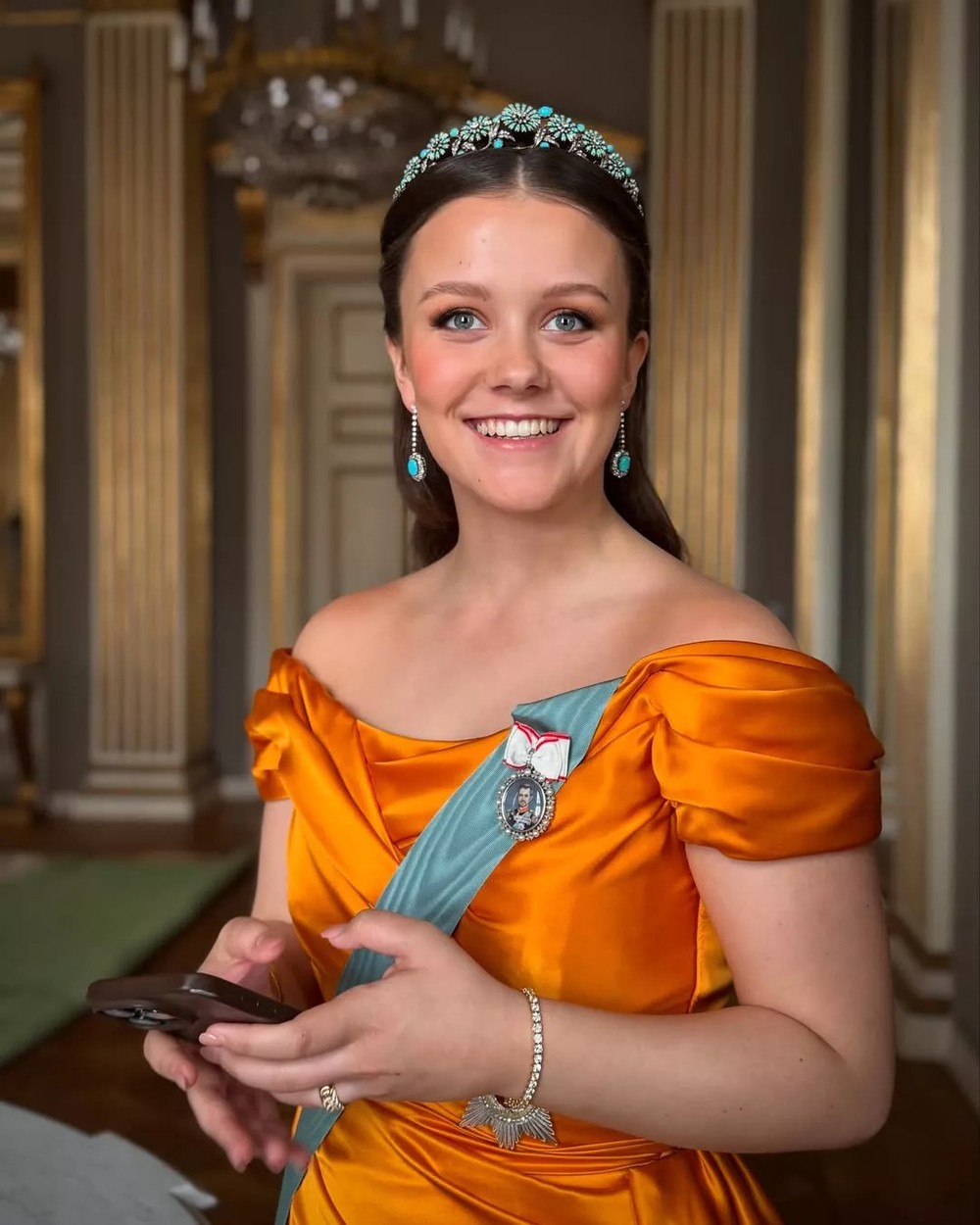 Princesa Isabella da Dinamarca posa para foto real com celular na mão
