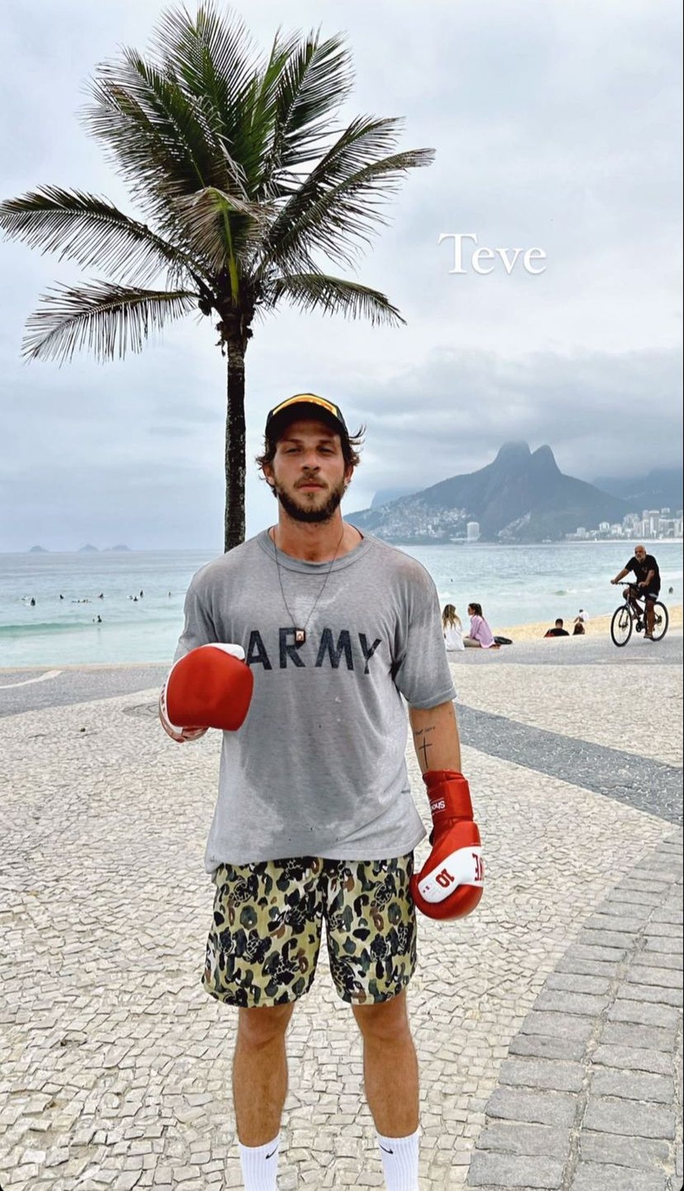 Chay Suede sua a camisa em treino de luta com vista para o mar