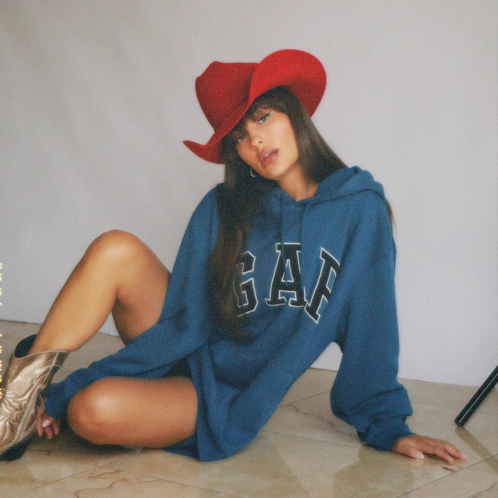 Thais Braz faz pose de cowgirl com chapéu e moletom em dia frio